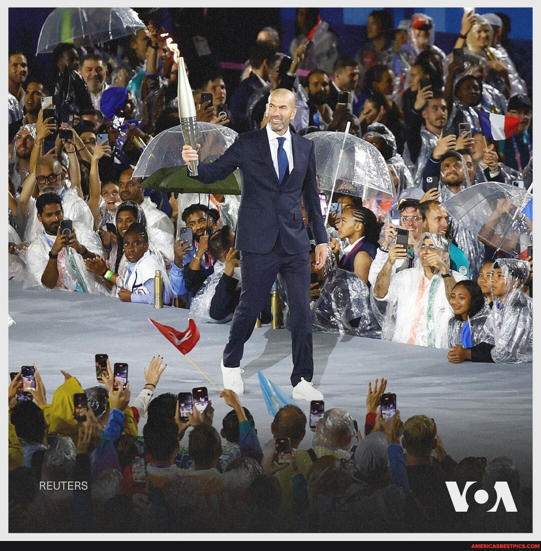 Zinedine Zidane holds the Olympic torch ahead of lighting the Olympic ...